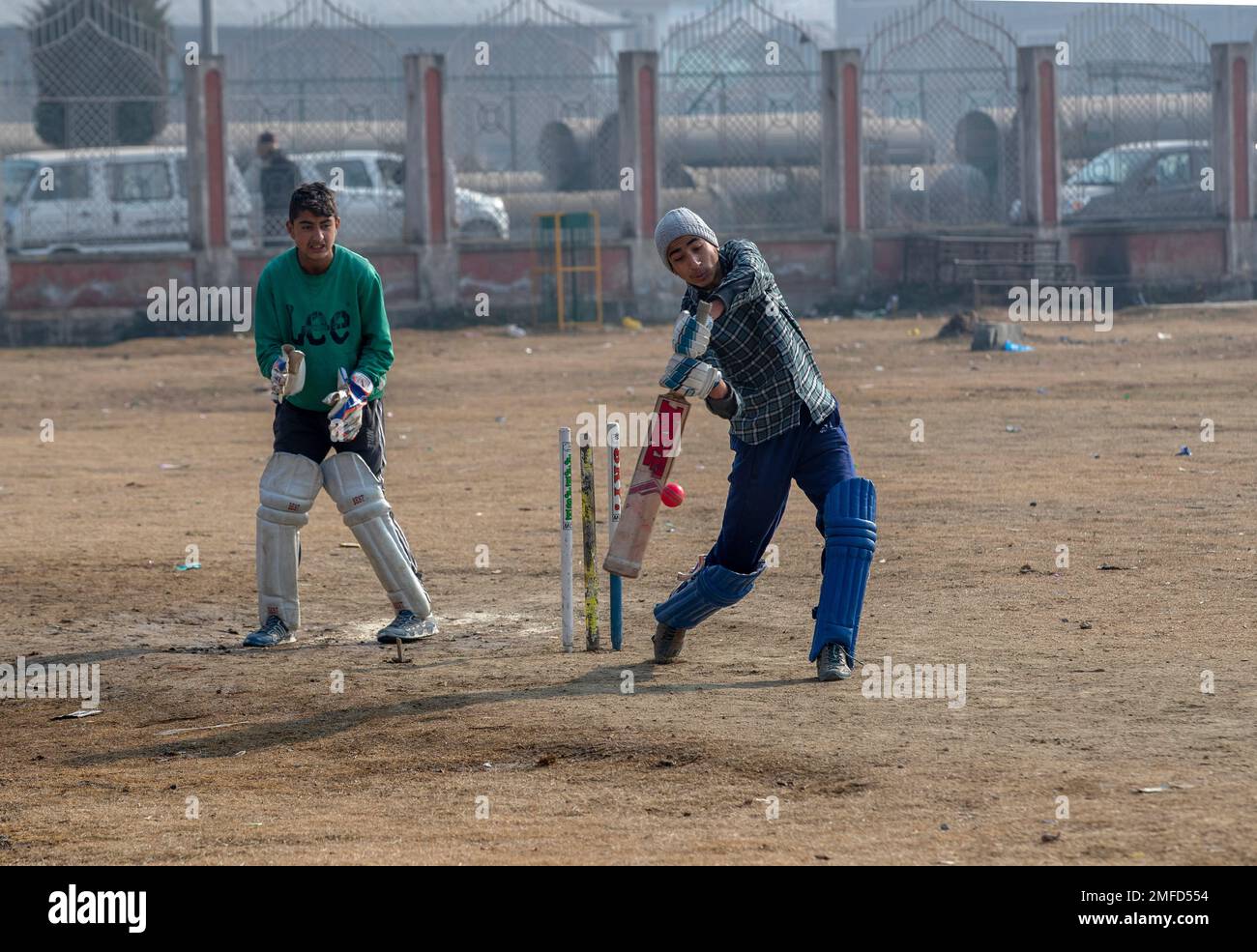 Kashmiri boys play a friendly game of cricket at a playground on a cold ...