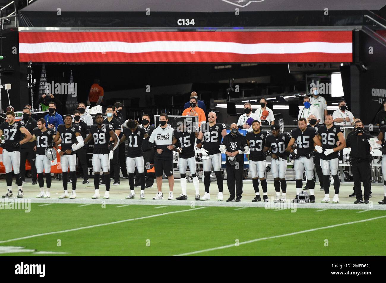 Las Vegas Raiders players stand during the national anthem before an ...