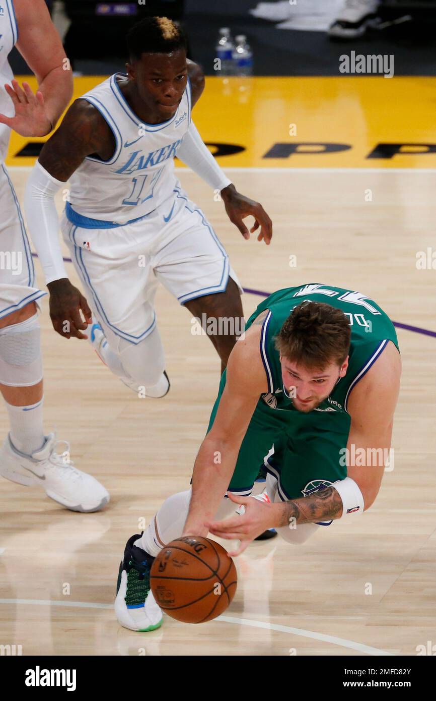 Dallas Mavericks' Luka Doncic (77) falls to the court while defend by ...