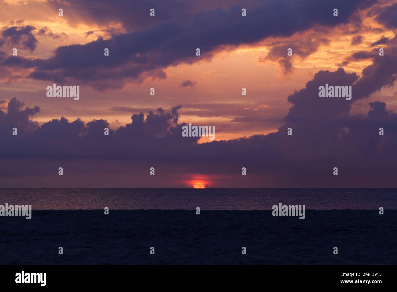 Coastal landscape with dramatic dark sky over ocean on a sunset ...