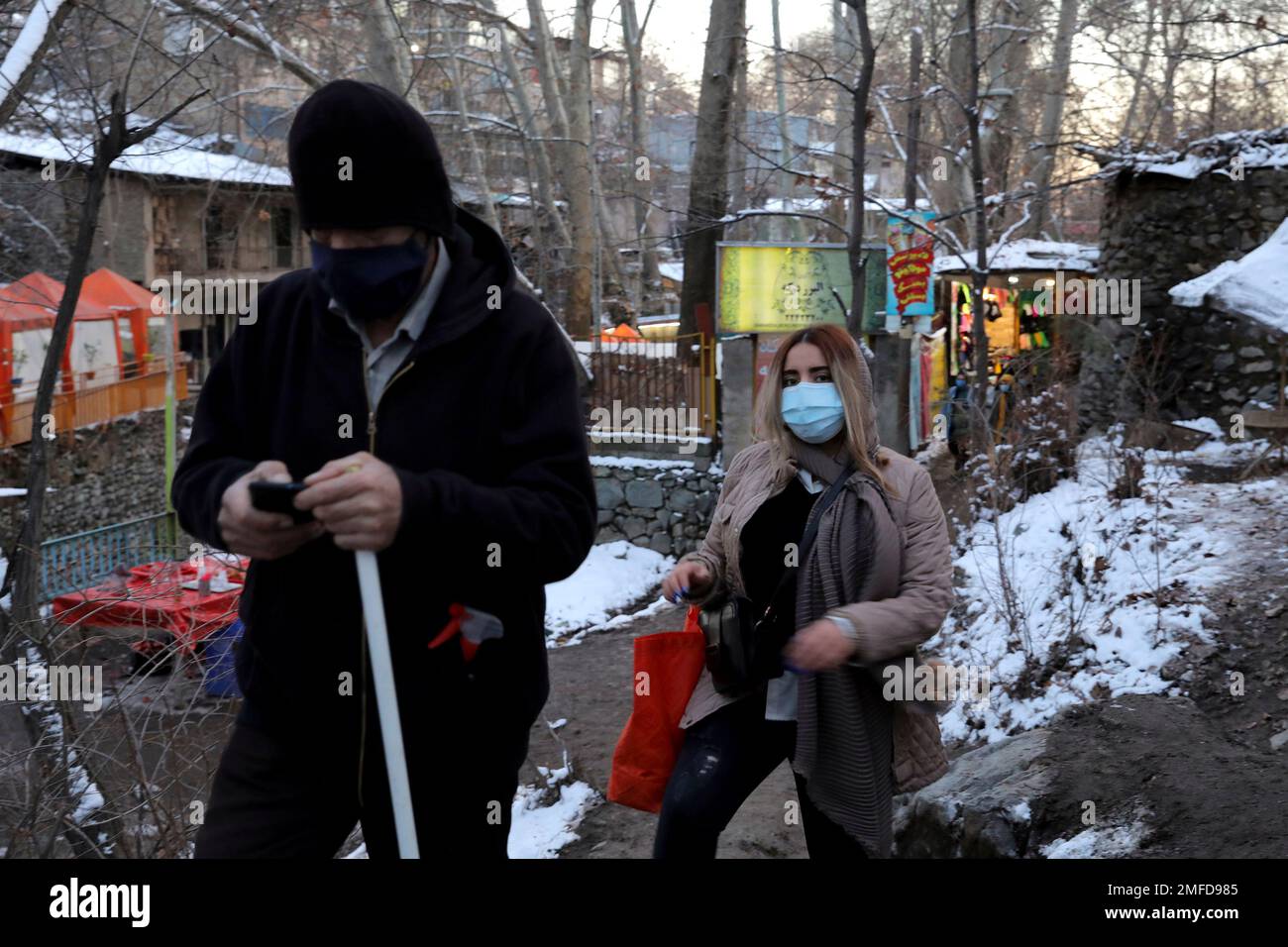 People wearing protective masks hike at the Darakeh mountainous area ...