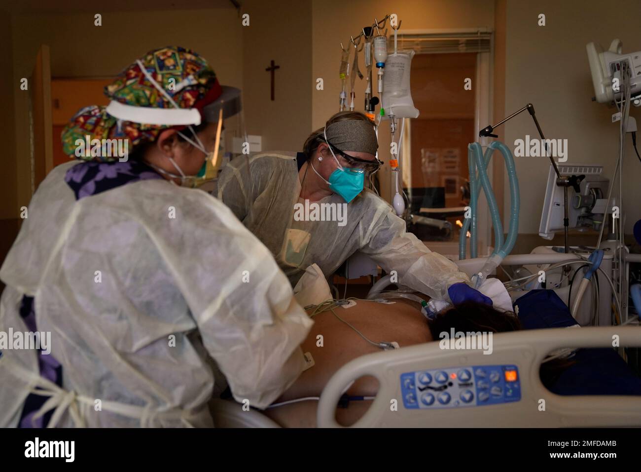 Registered nurses Robin Gooding, center, and Johanna Ortiz treat a ...