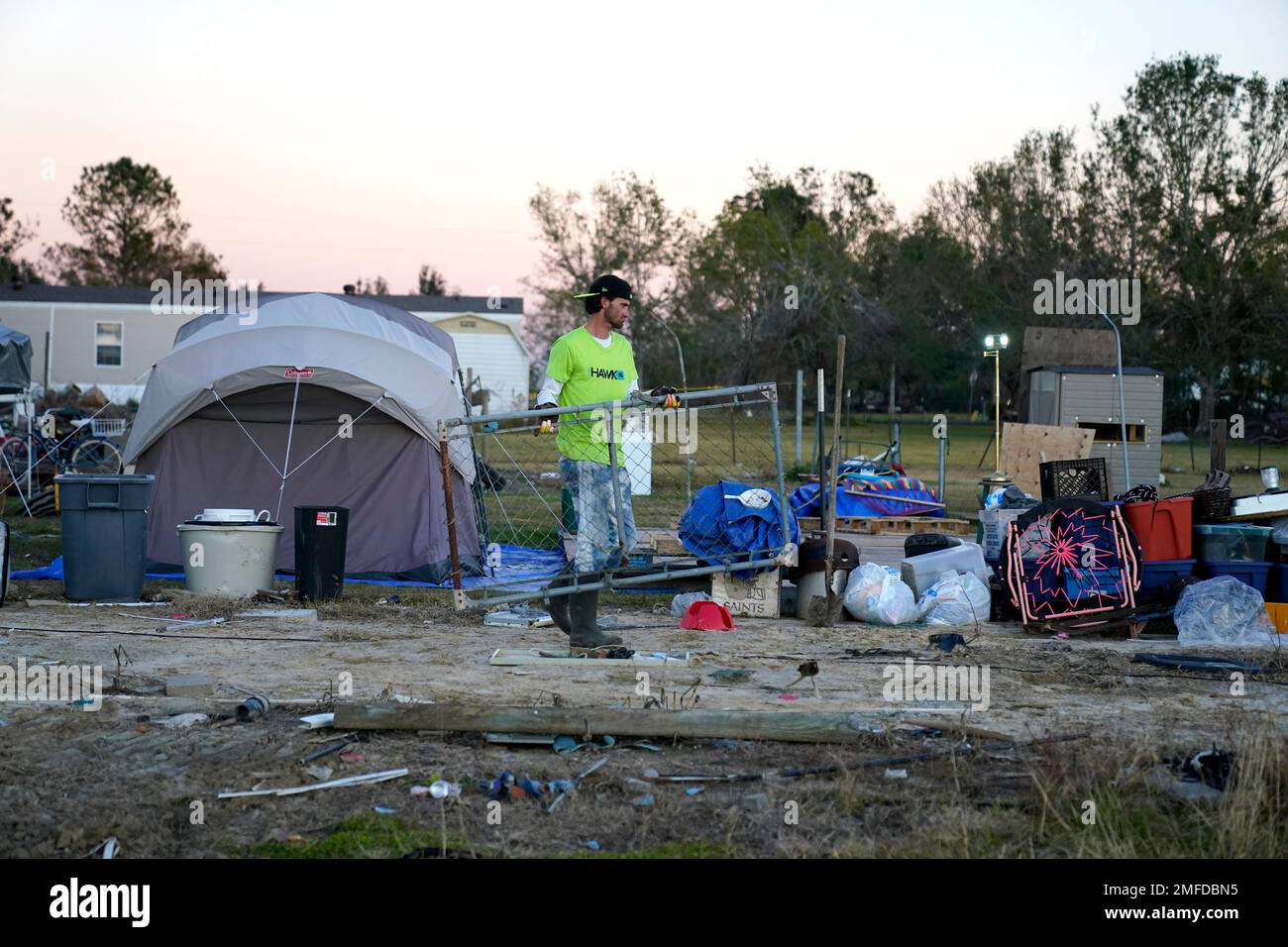 Ricky Trahan moves debris from his destroyed home, where he now lives ...