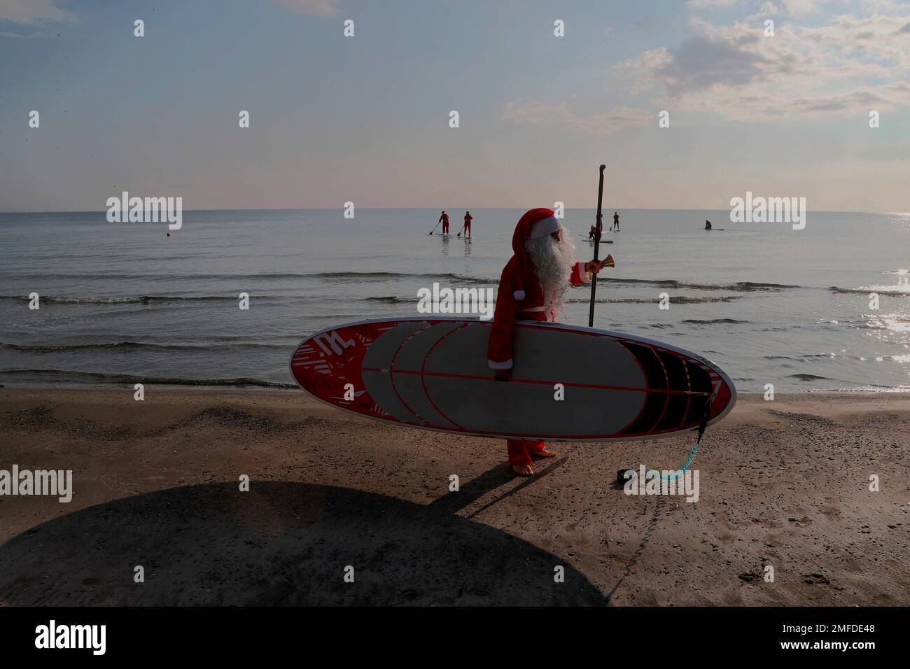Members of a windsurfing center wear Santa Claus costumes as they ...