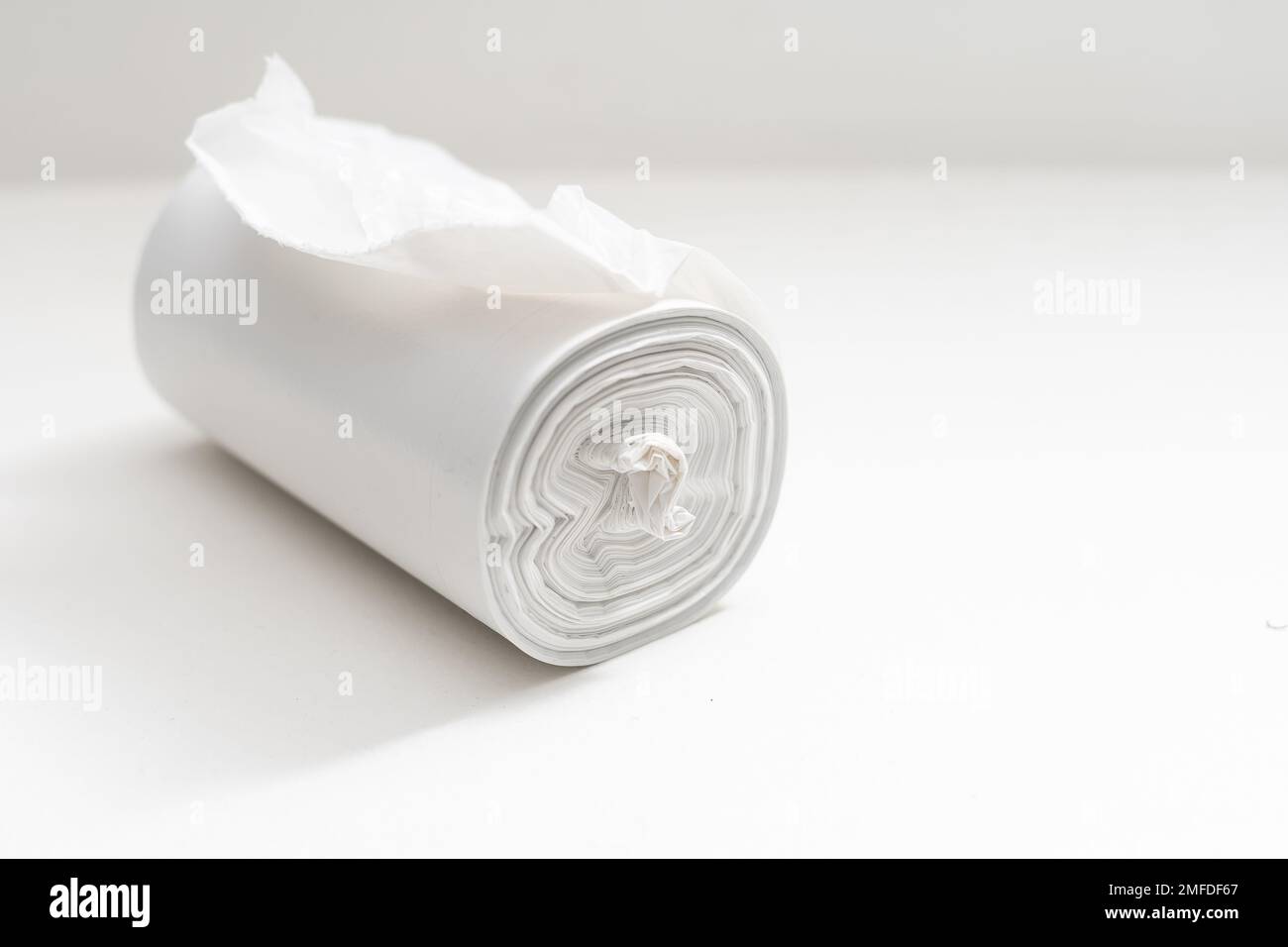 White plastic polyethylene trash bag roll isolated over the white ...