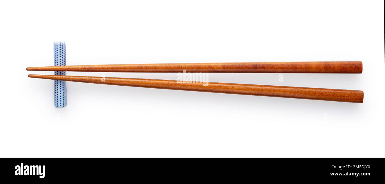 Wooden chopsticks and chopstick rests placed on a white background ...