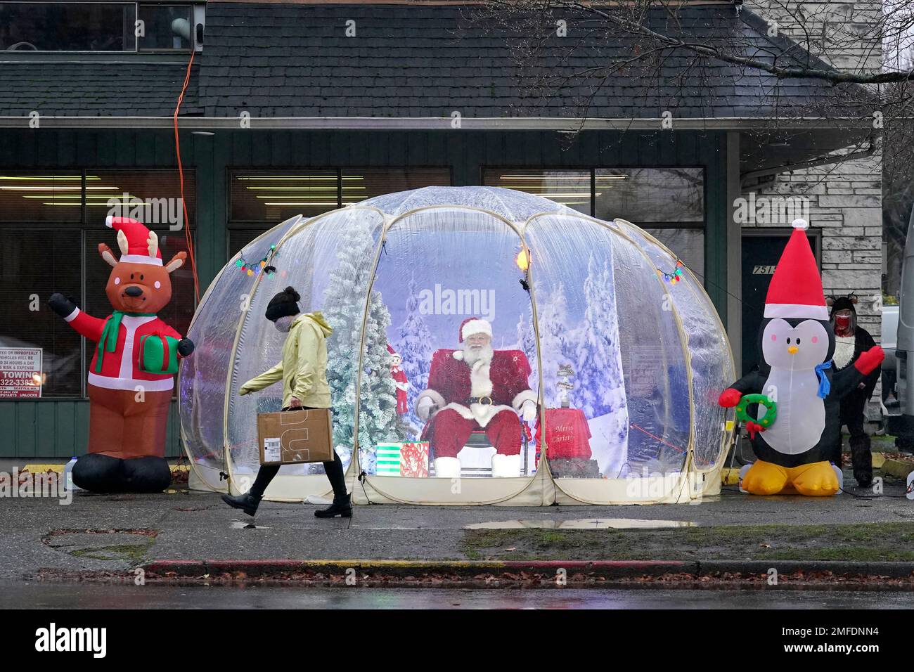 Santa, portrayed by Dan Kemmis, watches as a pedestrian passes by as he ...