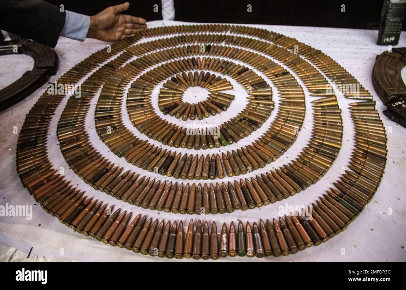 An Indian police official arranges bullets surrendered by the cadres of ...