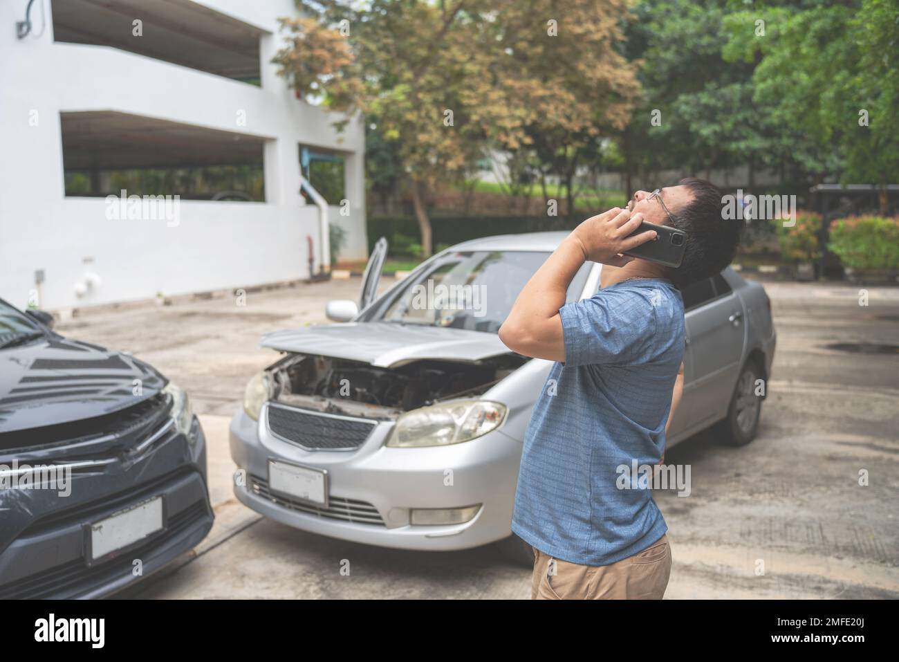 One man reporting car crash damage calling insurance and Claim roadside ...