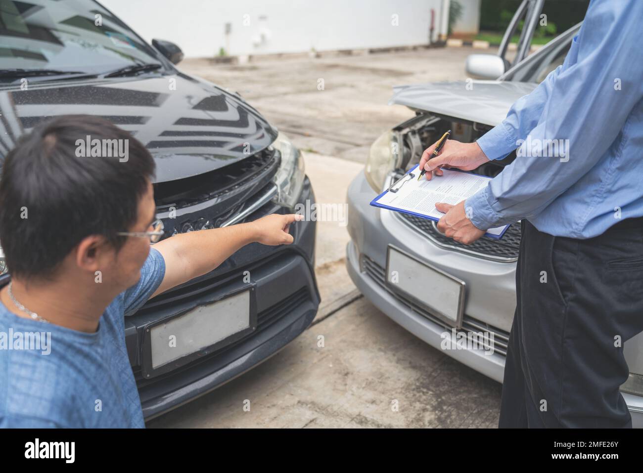 Insurance officer writing Insurance Claim Report on clipboard while ...