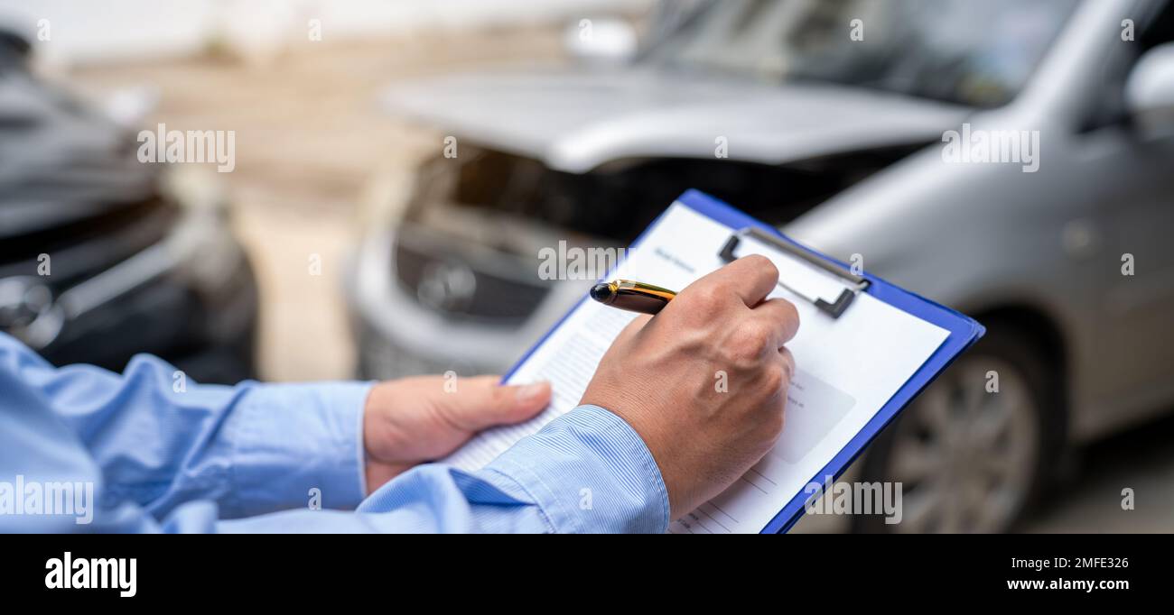 Insurance officer writing Insurance Claim Report on clipboard while ...