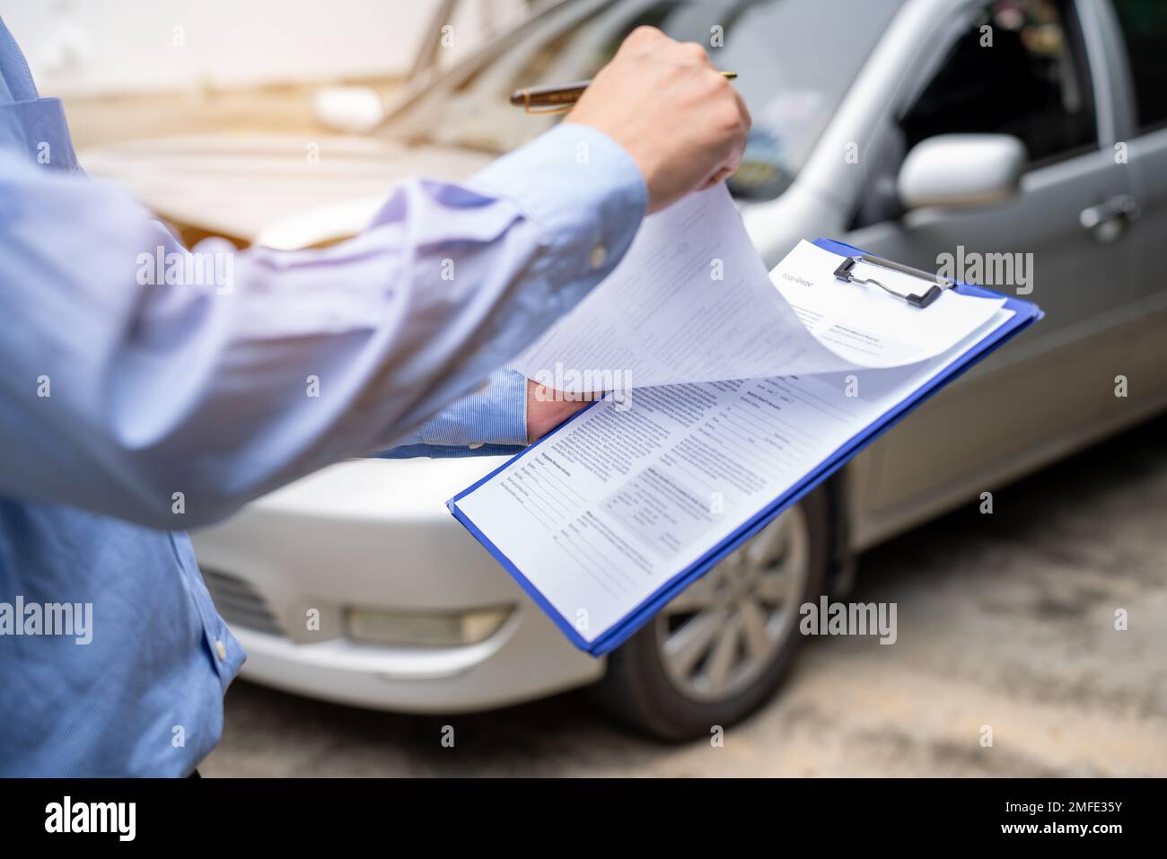 Insurance officer writing Insurance Claim Report on clipboard while ... Insurance officer writing Insurance Claim Report on clipboard while ...