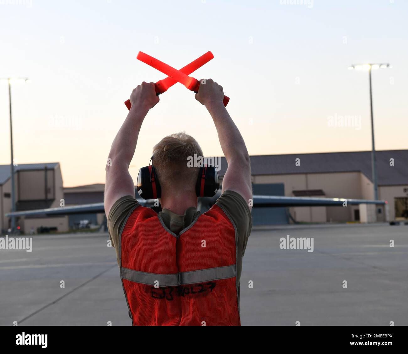 U.S. Air Force airman directs a B-1B Lancer onto the runway during a ...