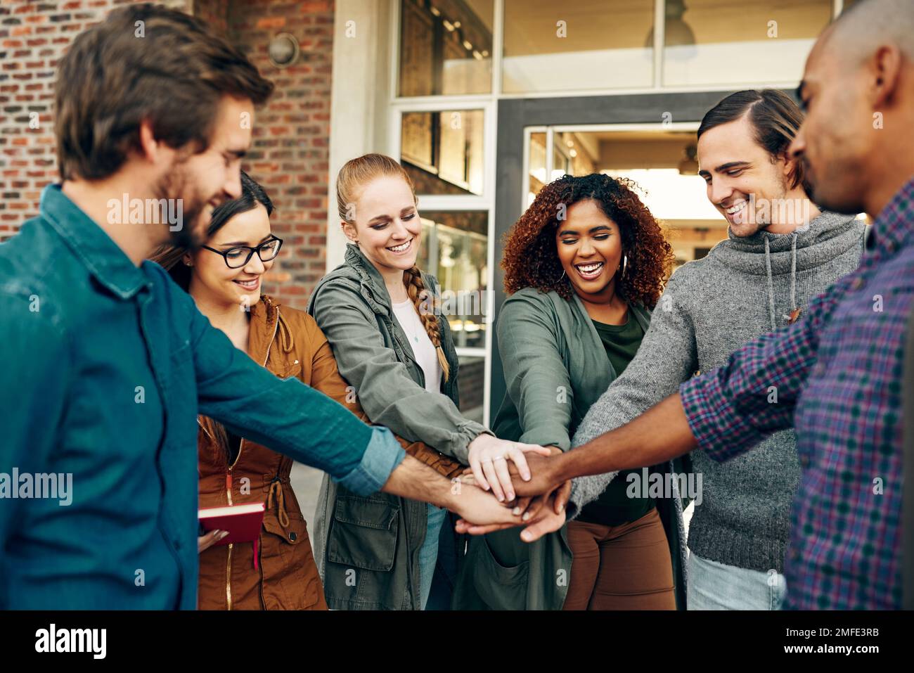 Lets get our learning on. a group of young students joining their hands ...