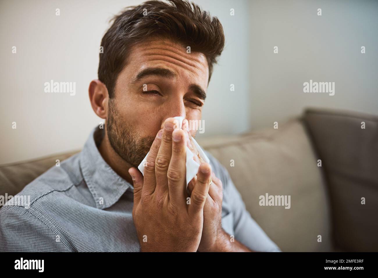 Time to stock up on tissues. Portrait of a uncomfortable looking young ...