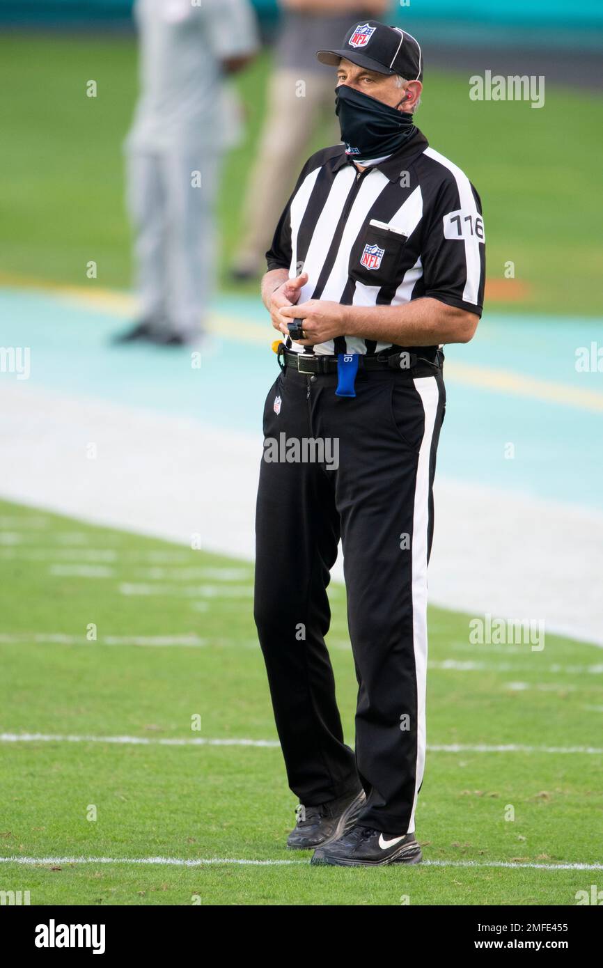 NFL Field Judge Mike Weatherford wears a mask on the field as the Miami ...