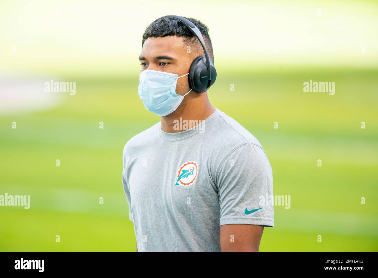 Miami Dolphins quarterback Tua Tagovailoa (1) wears a mask as he warms ...