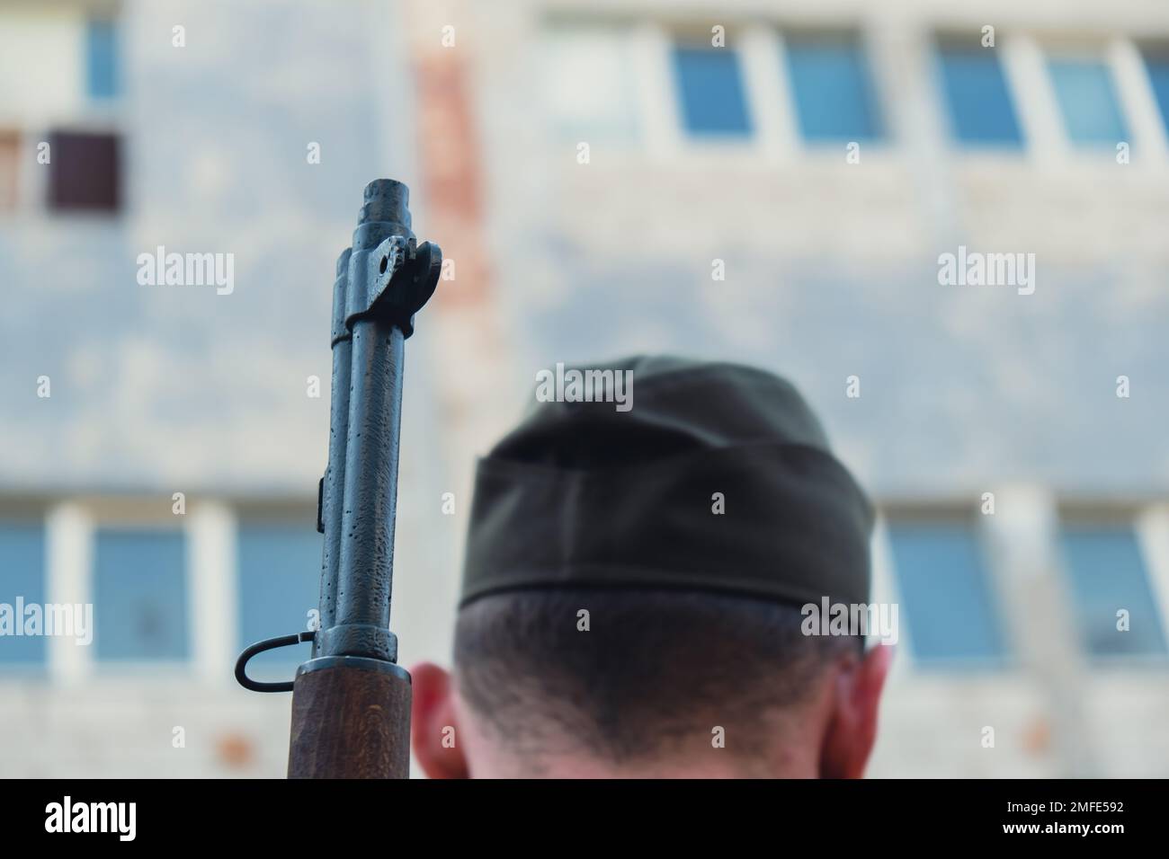 Back view of unrecognizable man in body armor during war weapon ...