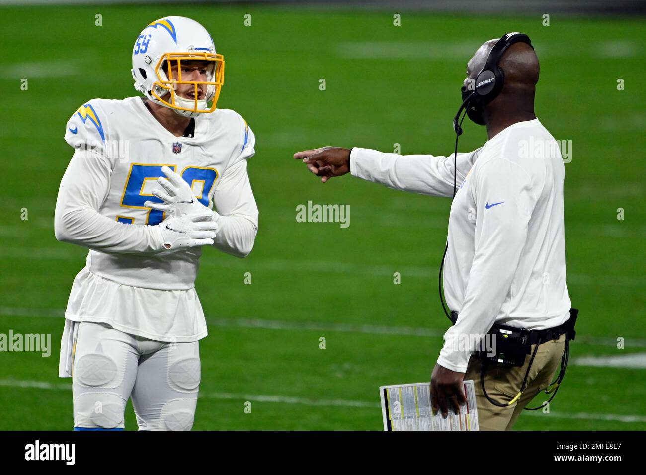 Los Angeles Chargers head coach Anthony Lynn talks with outside linebacker Nick Vigil (59 ...