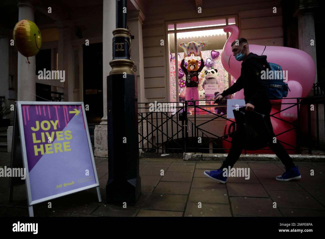 A man wearing a face mask to curb the spread of coronavirus walks past ...