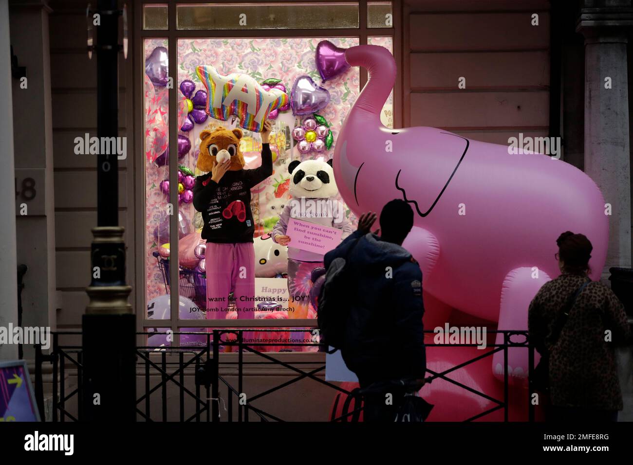 A passerby waves at costumed actors performing as part of a pop-up art ...