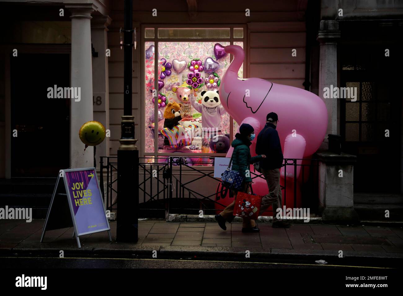 A person wearing a face mask to curb the spread of coronavirus walks ...