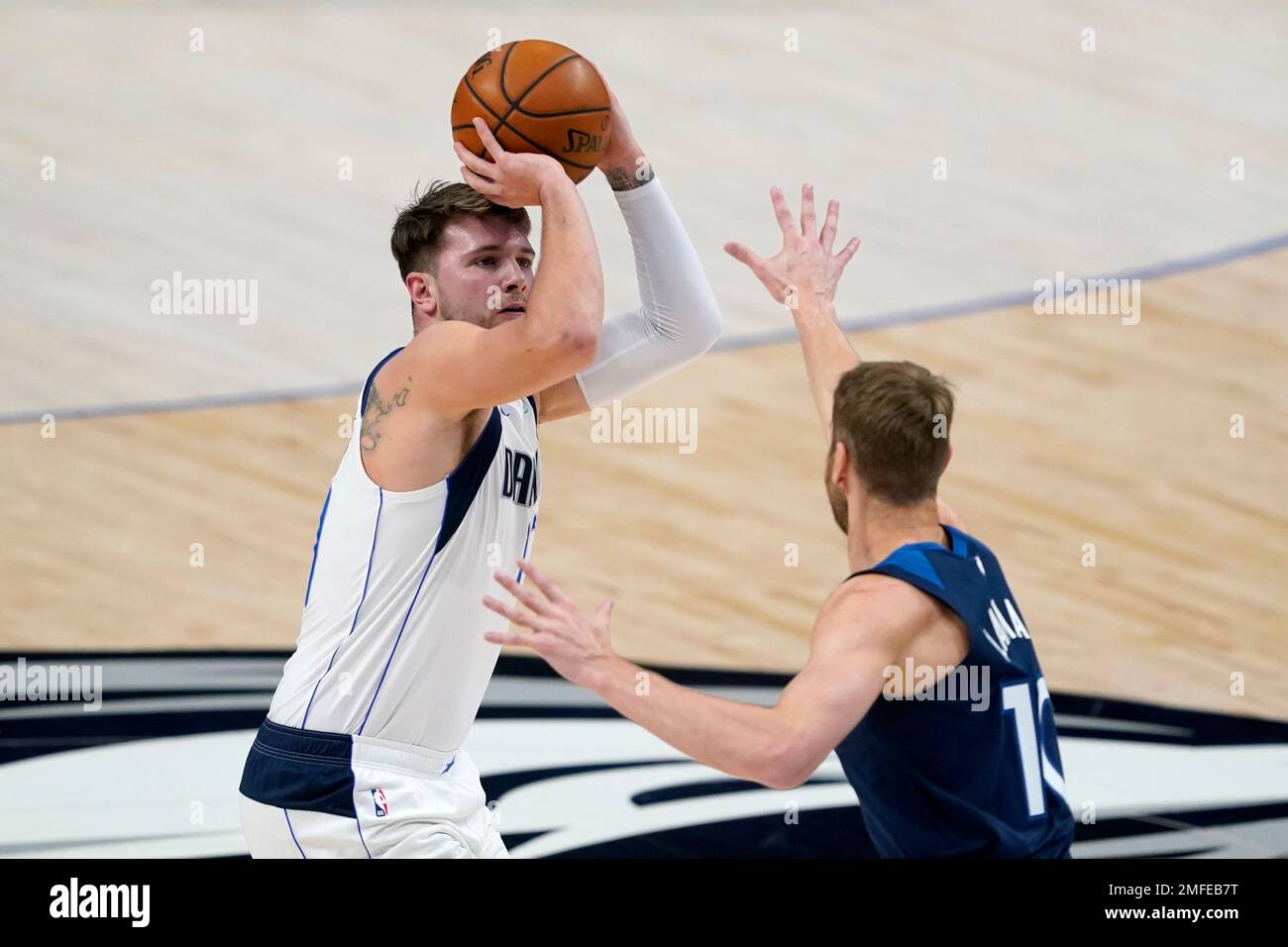 Dallas Mavericks guard Luka Doncic, left, takes a shot as Minnesota ...