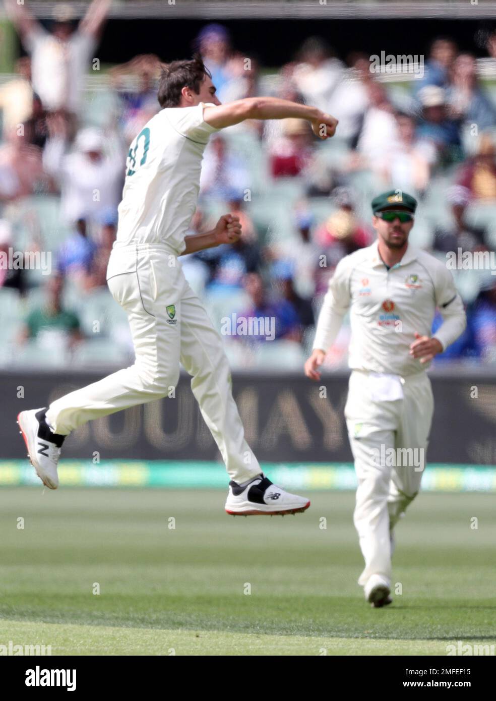 Australia's Pat Cummins, left, jumps up while celebrating after bowling ...
