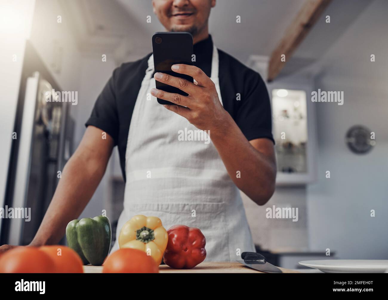 Cooking vegetables, phone and man in kitchen while online with house ...