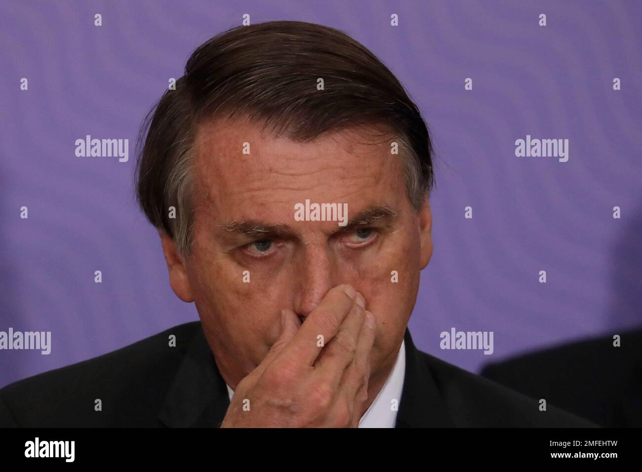 Brazilan President Jair Bolsonaro touches his nose during a ceremony ...