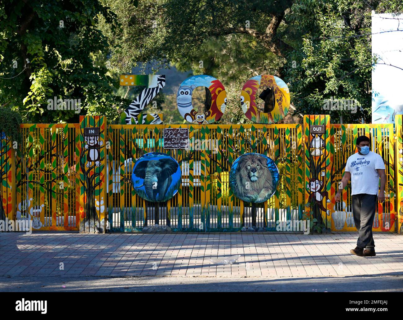A Pakistani walks past the main gate of the Marghazar Zoo which is ...