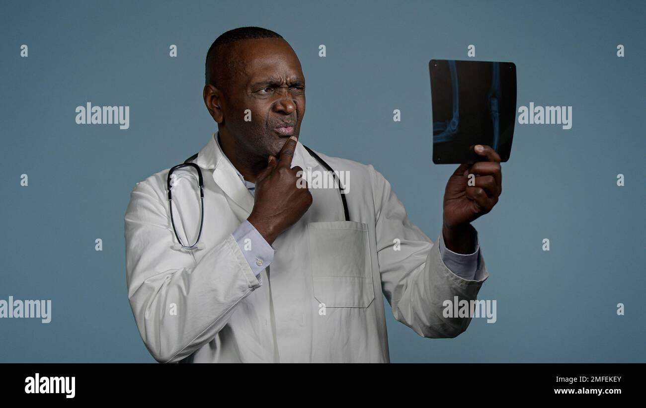 Mature serious man radiologist doctor examining x-ray check results ...