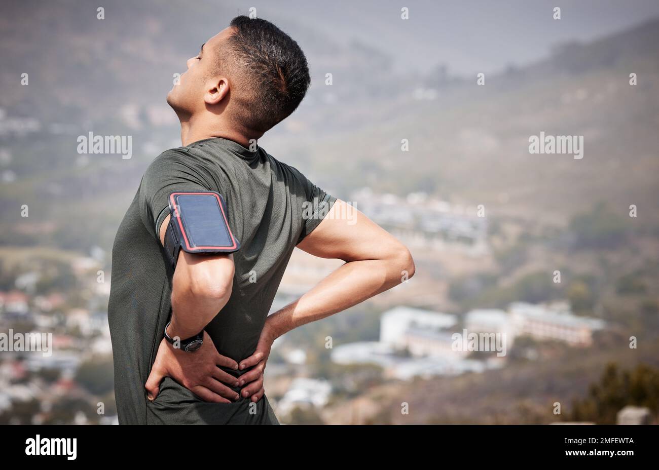 Fitness, pain and man with hands on back, hurt muscle on run with ...