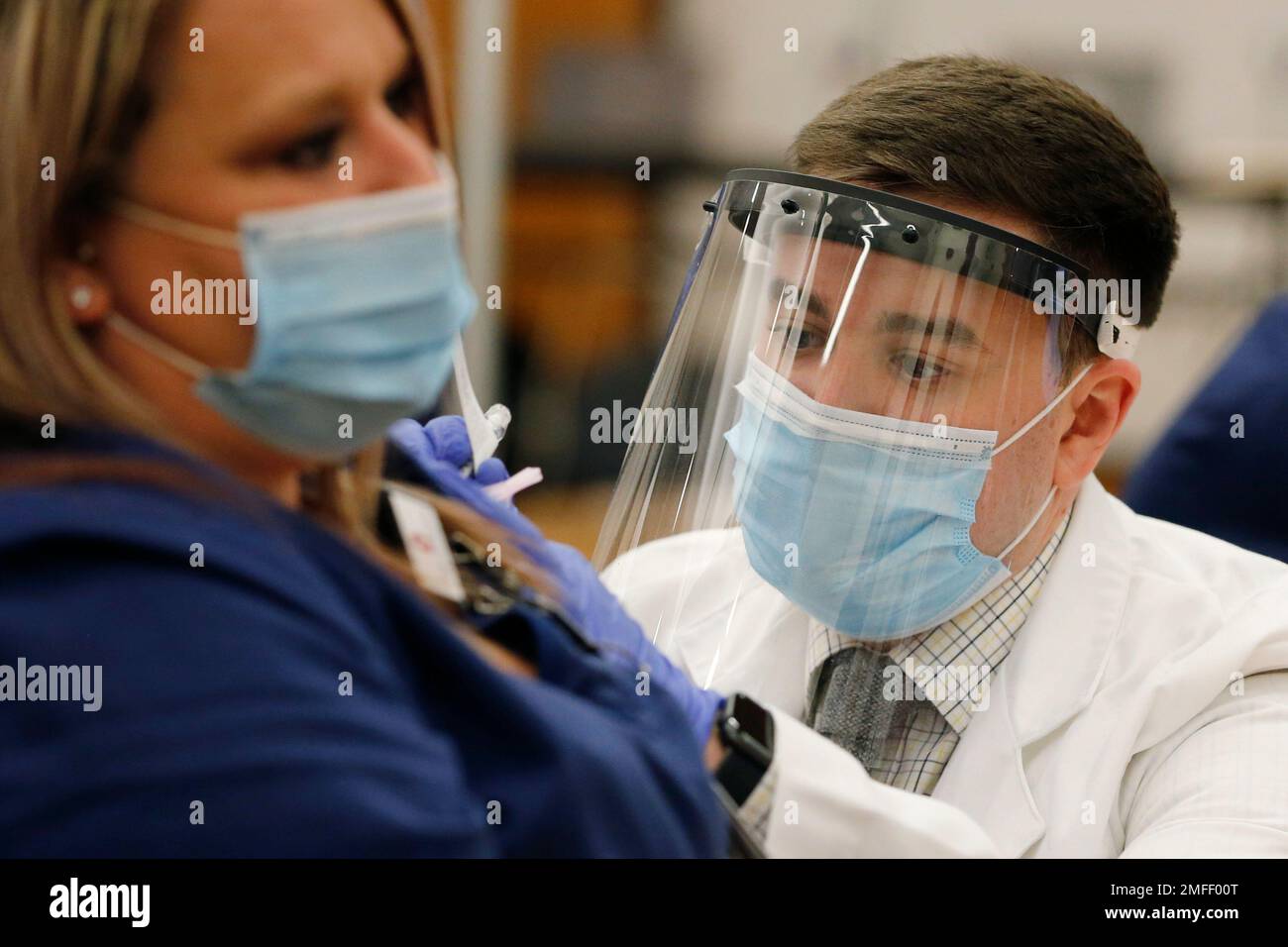 Ohio State employee Cory Coffey, right, administers a Pfizer-BioNTech ...