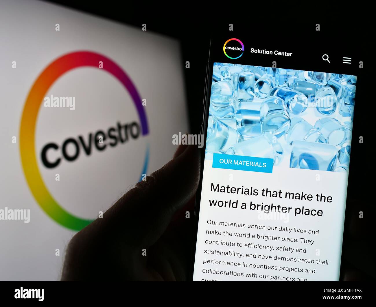 Person holding cellphone with webpage of German chemicals company ...