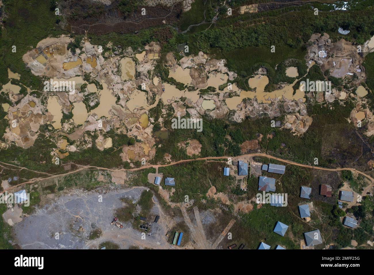 Houses stand next to a diamond mining site in Koidu, district of Kono ...
