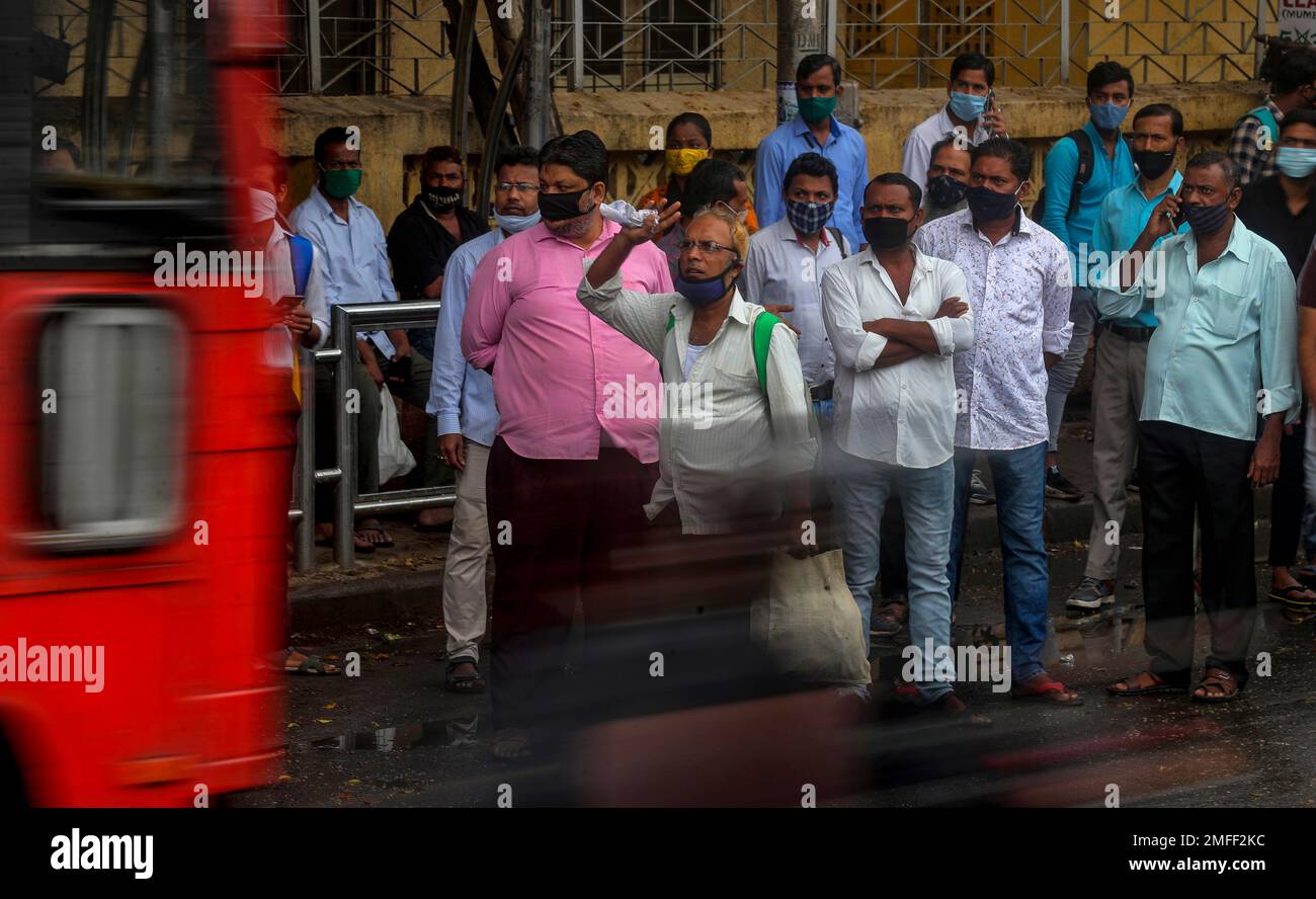 A man gestures to the driver of a bus as people wearing masks as a ...