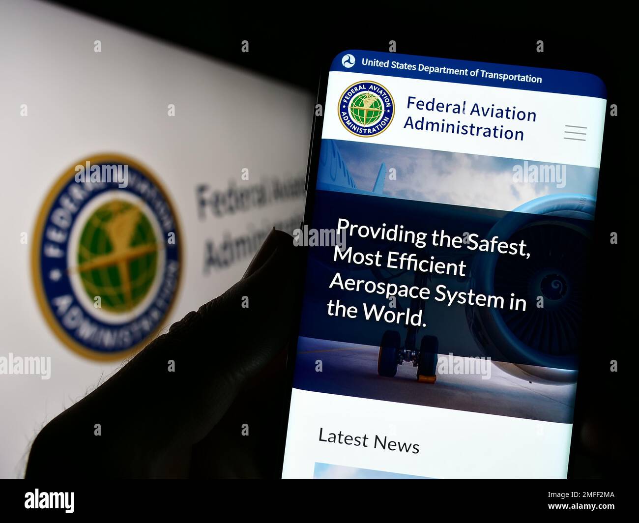 Person holding smartphone with website of US Federal Aviation ...