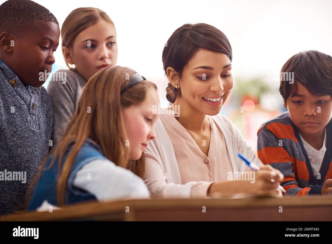 She knows how to simplify learning for her students. elementary school kids getting help from ...