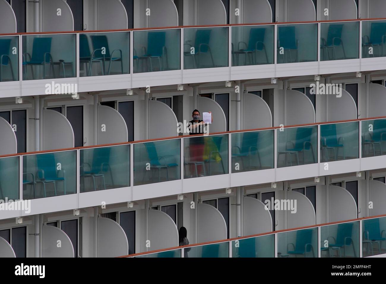 A passenger shows a note from the World Dream cruise ship docked at Kai ...