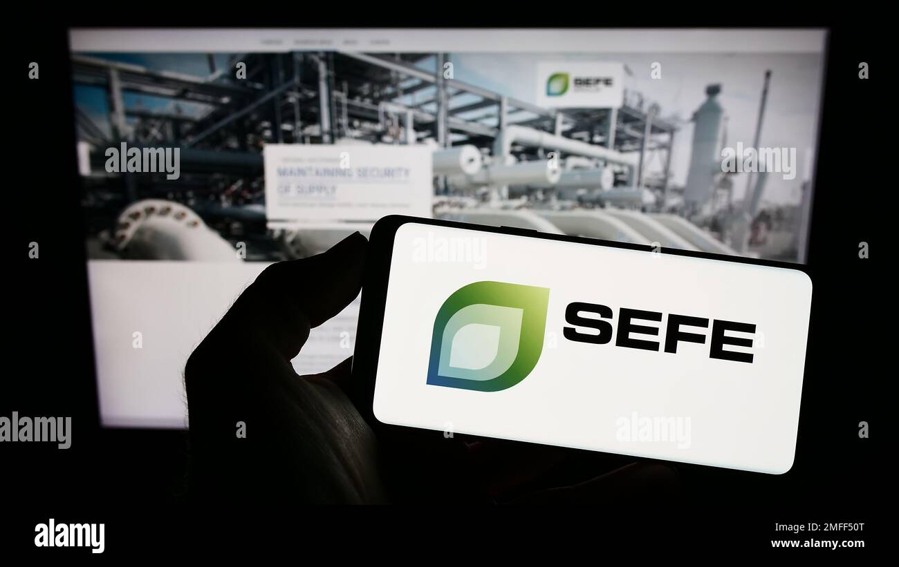 Person holding mobile phone with logo of company SEFE Securing Energy ...