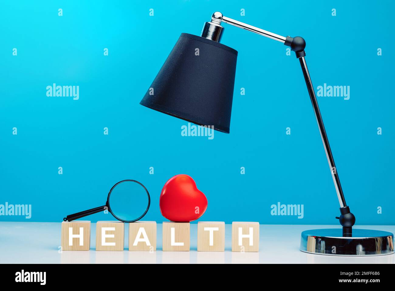 Red heart and magnifying glass on top of wooden cubes with the word ...
