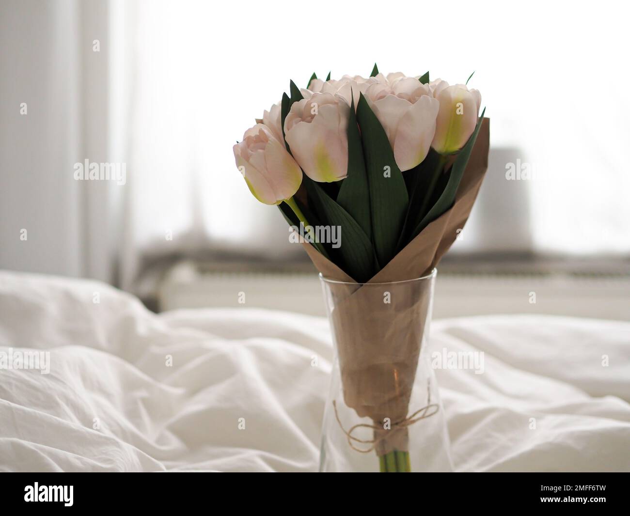 A small pretty bouquet of white tulips in a vase in the bedroom Stock ...