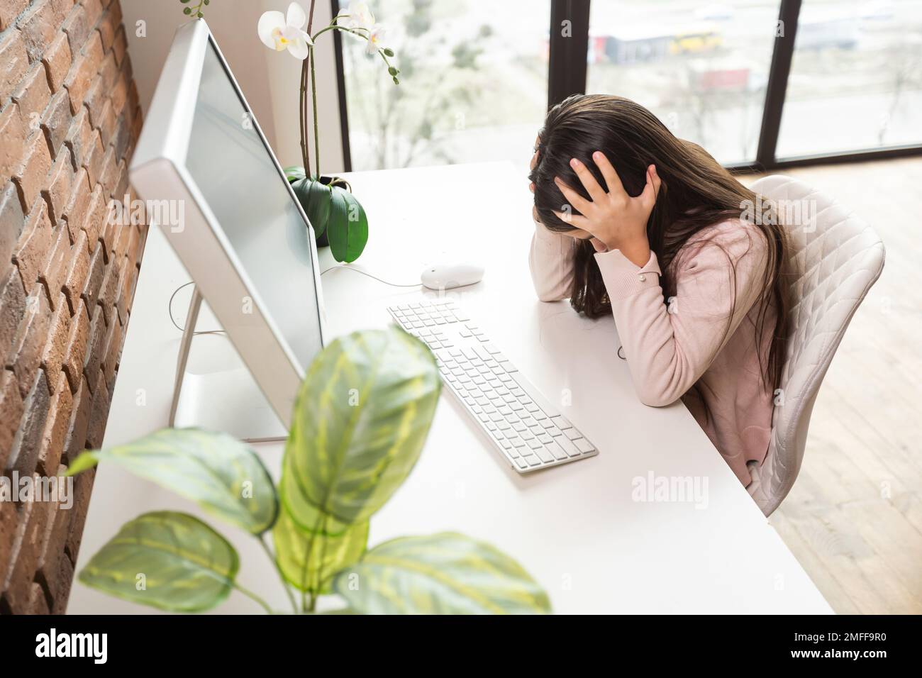 Sad teenage girl sitting near laptop Stock Photo - Alamy