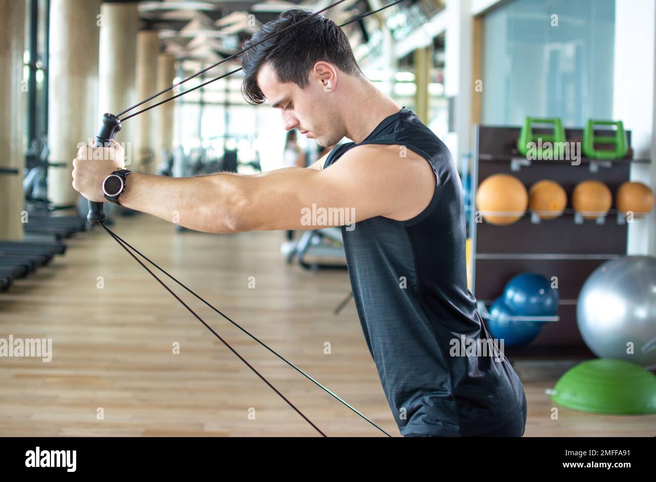 Man pulling cables. Handsome athlete male lifting up and push up on ...