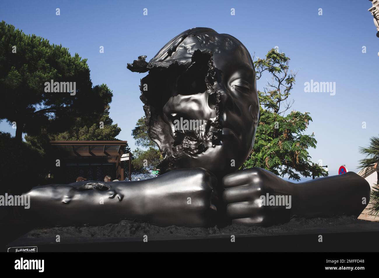 A sculpture of a head with torn out skin and skull next to the ...