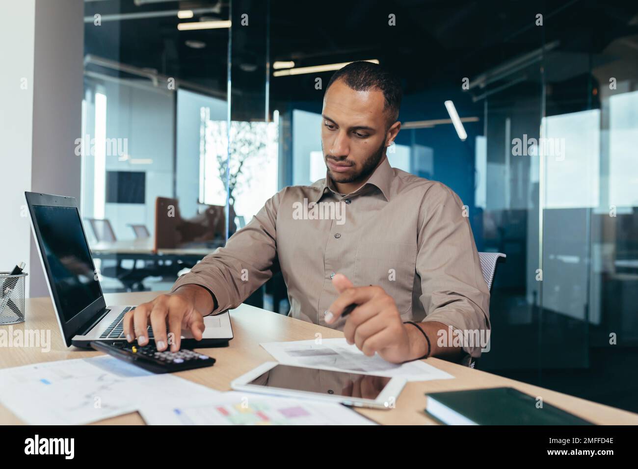 A young African-American male accountant, auditor works in the office ...