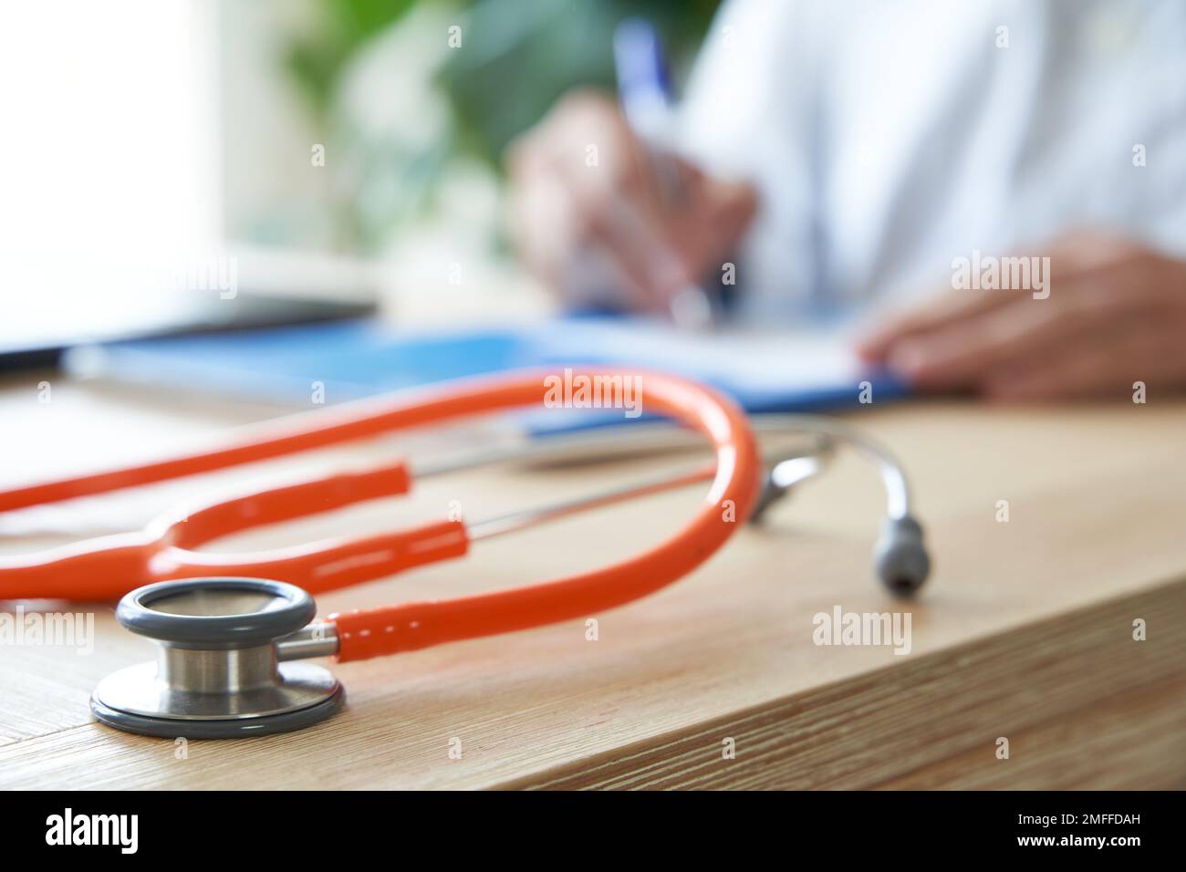 Doctor writing prescription in his office by stethoscope Stock Photo ...