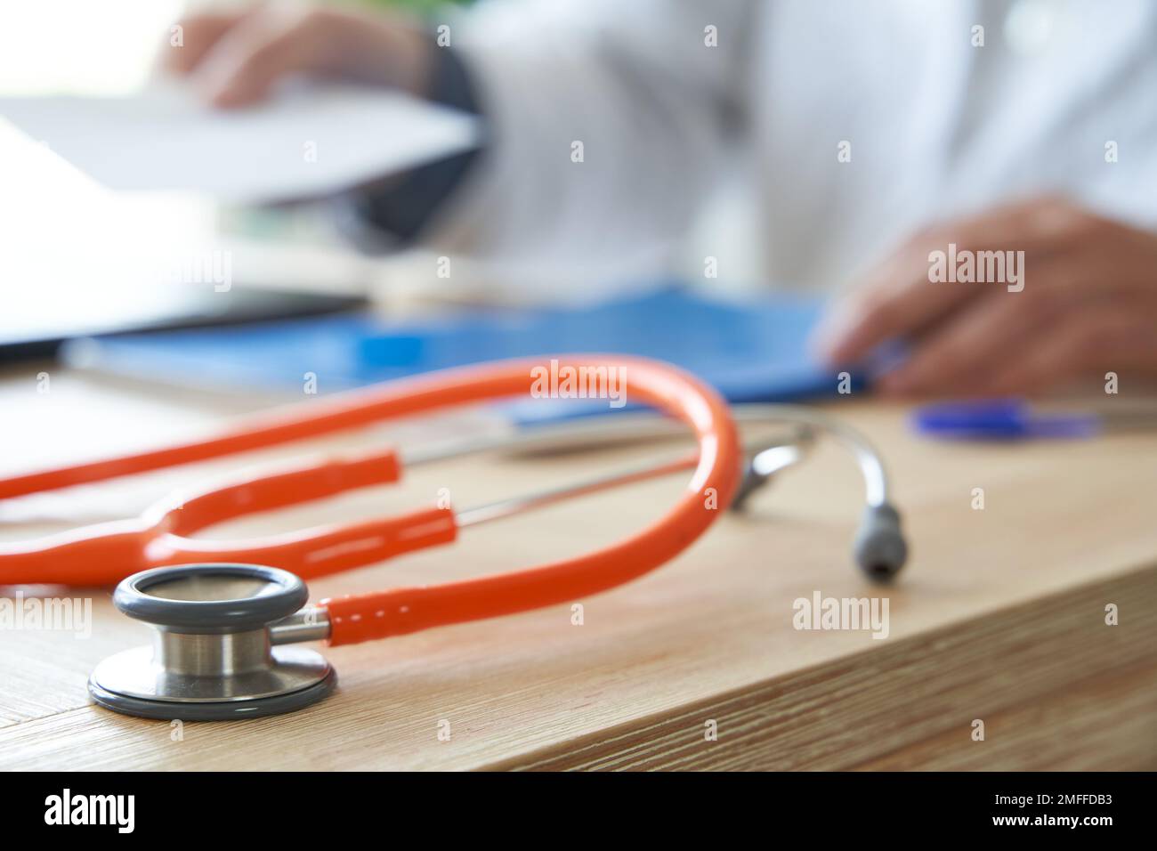 Doctor handing prescription to patient in his office by stethoscope ...