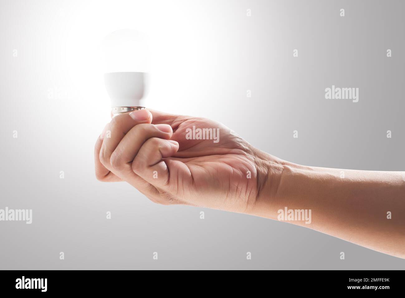 Light bulb on human hand with gray background Stock Photo - Alamy